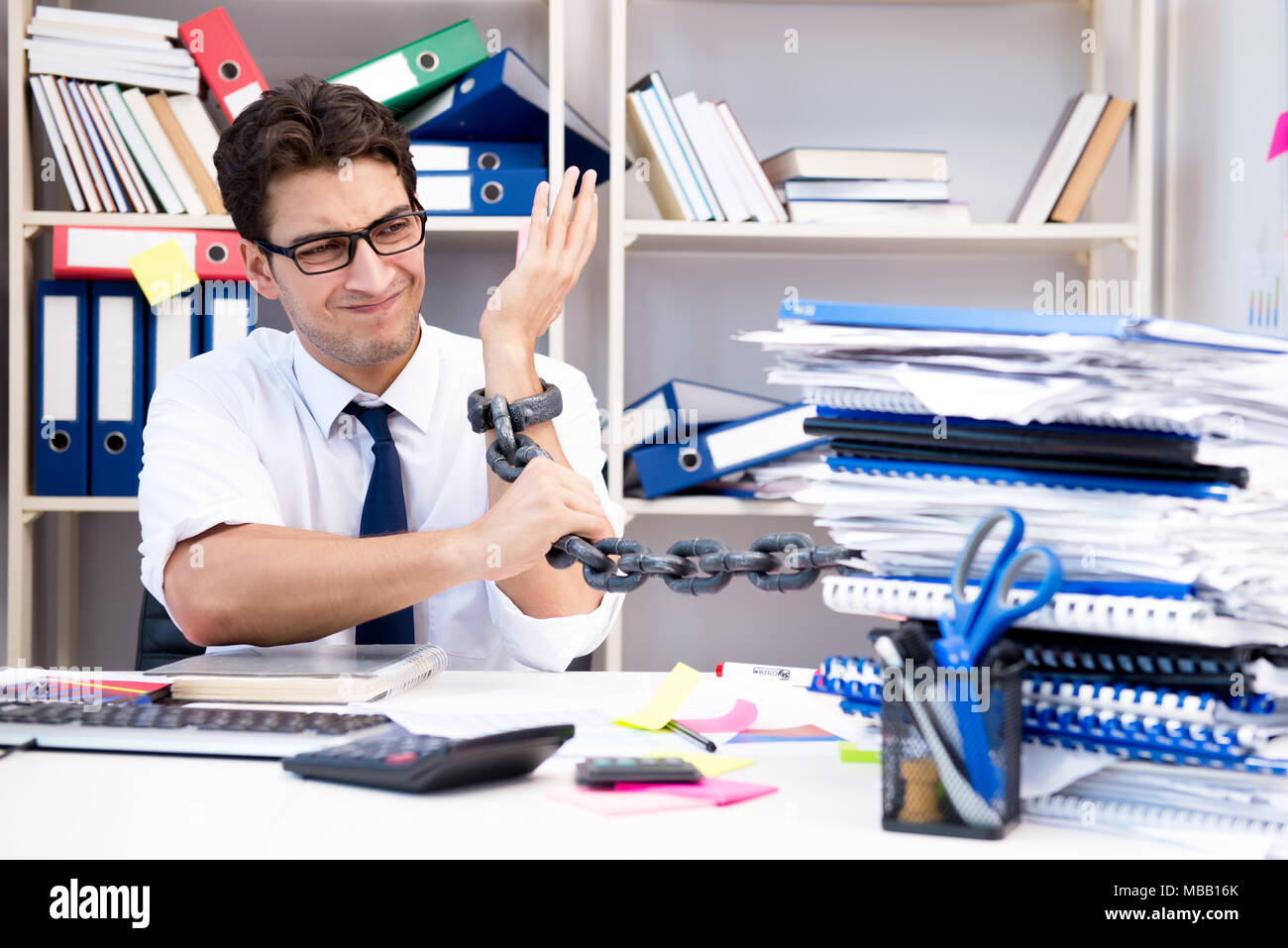 Employee attached and chained to his desk with chain Stock Photo - Alamy
