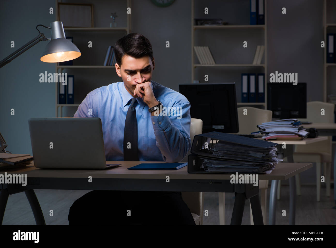 Employee working late at night at important report Stock Photo - Alamy
