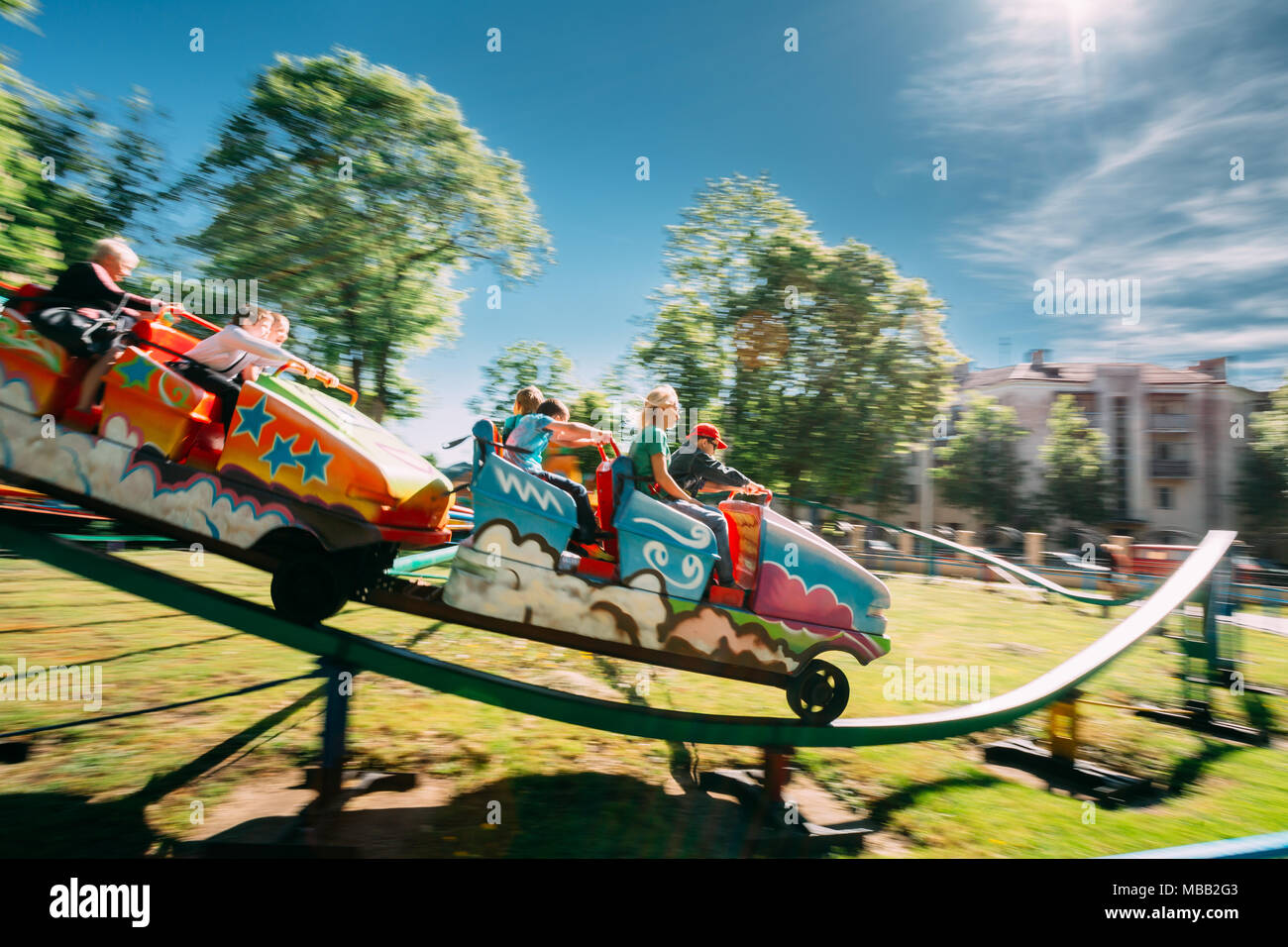 People Having Fun On Rollercoaster In Park. Photo With Zoom Blur For ...