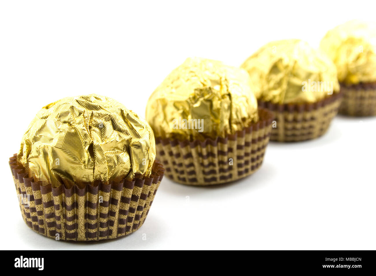 gold chocolate balls on white Stock Photo - Alamy