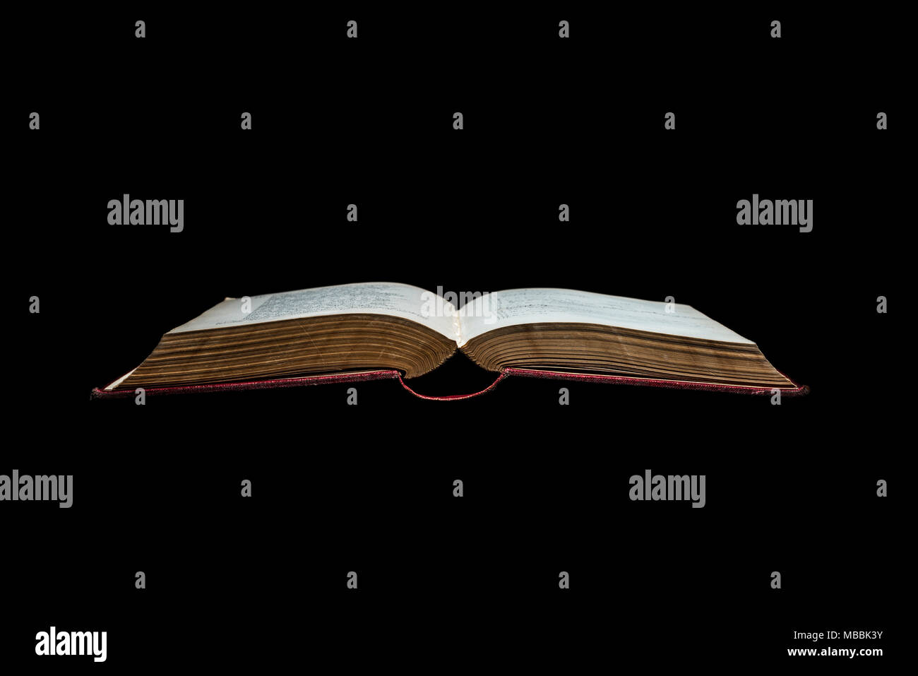 very old book opened in half, on black background Stock Photo - Alamy
