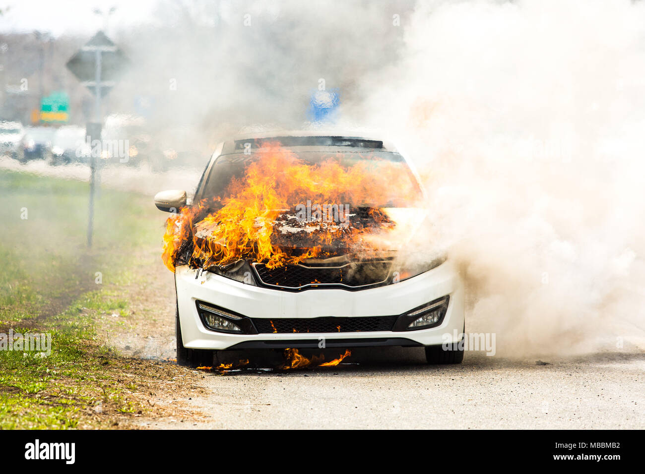 Burning car on fire on a highway road accident at day Stock Photo - Alamy