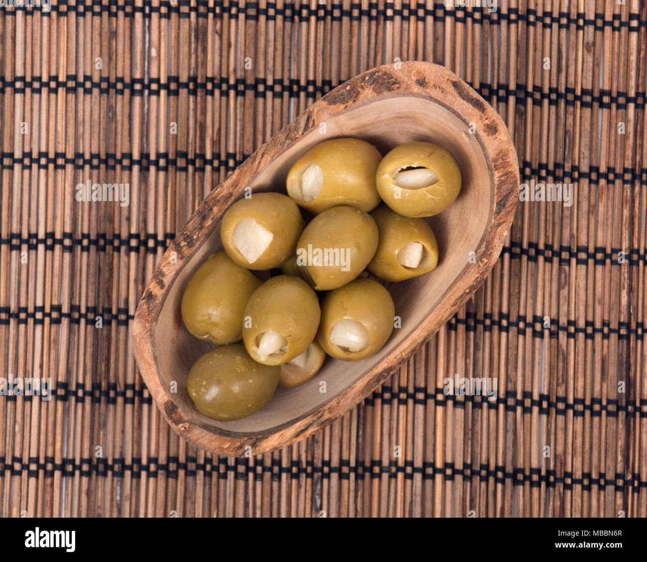 Green colossal olives hand stuffed with garlic gloves in olive wood ...
