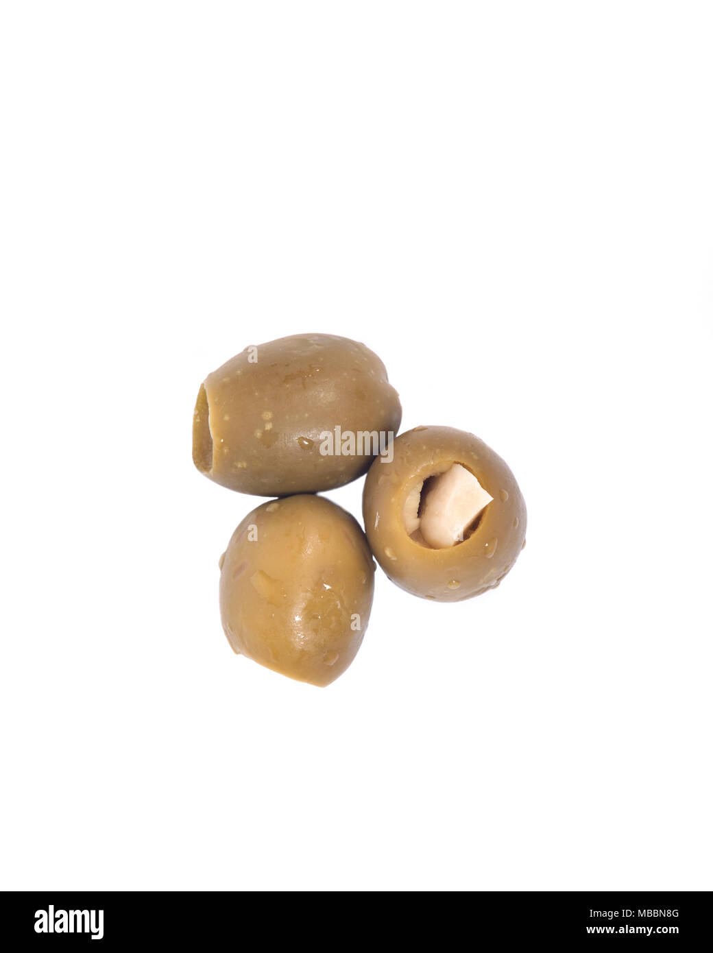 Green colossal olives hand stuffed with garlic gloves isolated on white ...