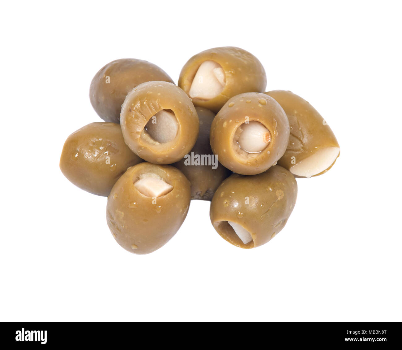 Green colossal olives hand stuffed with garlic gloves isolated on white ...