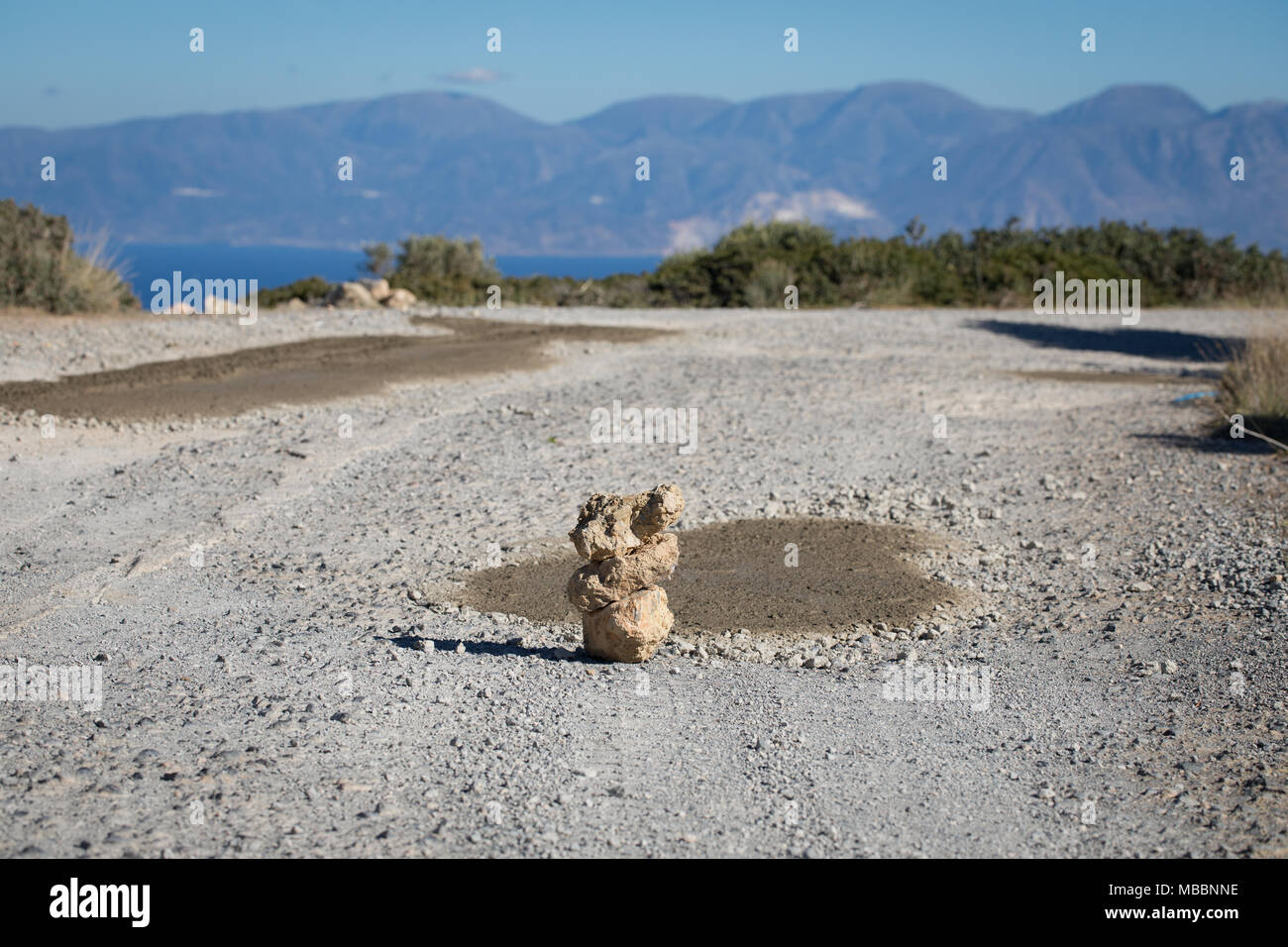 Stones pyramid used as a street sign, newly repaired road, freshly ...