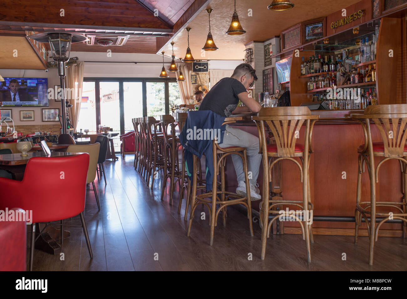 A man sitting in a modern pub. Malia, Crete / Greece Stock Photo - Alamy