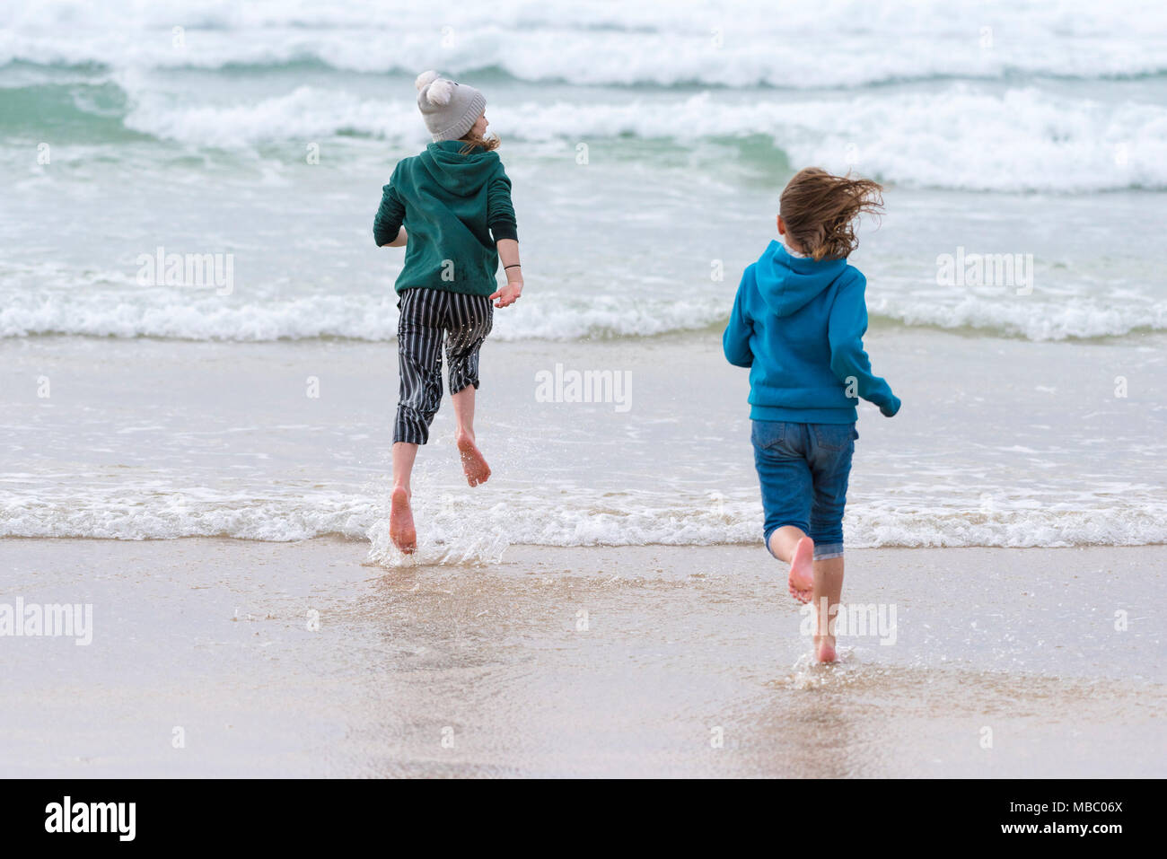 Young girls running into the sea Stock Photo - Alamy