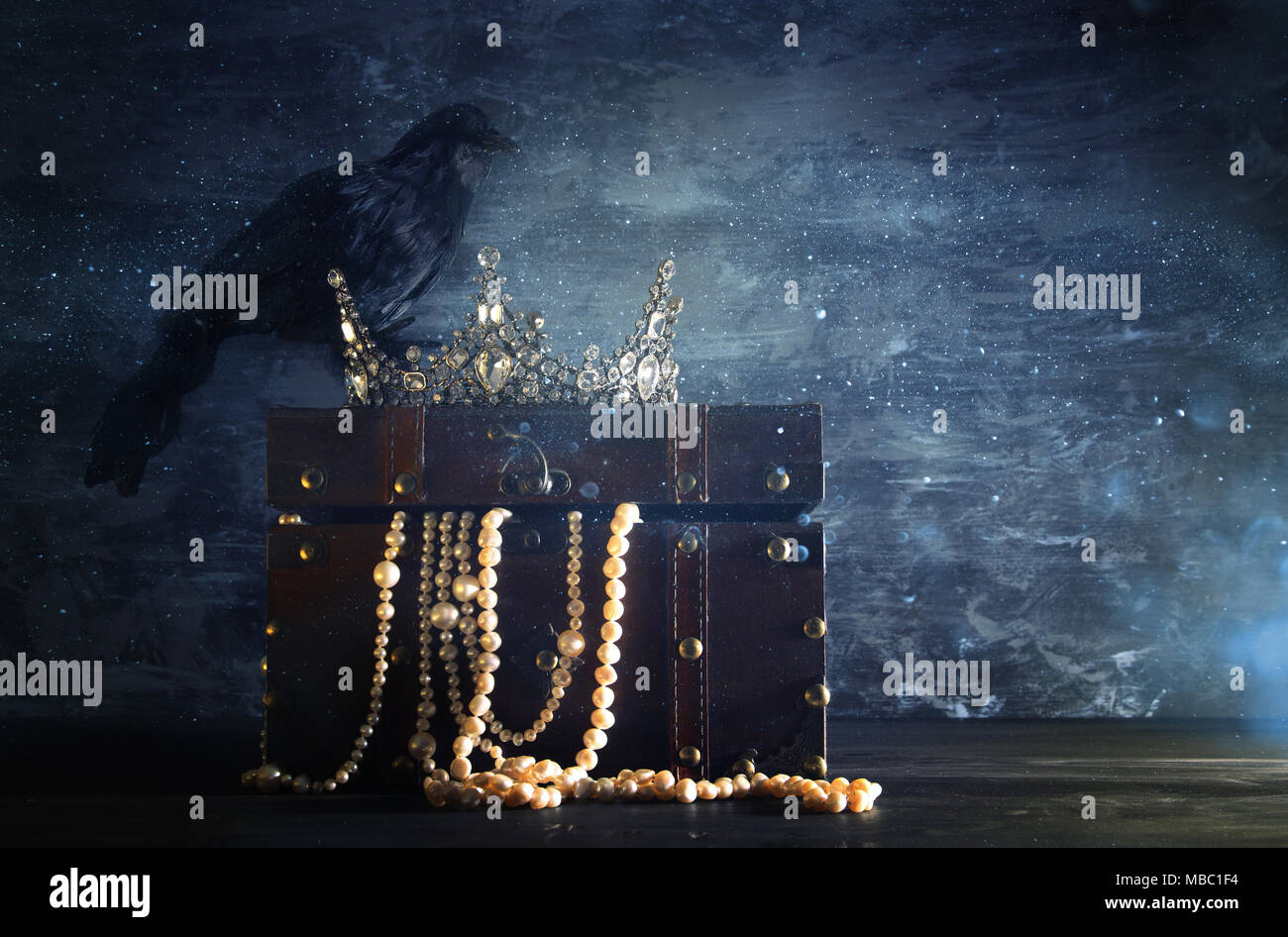 low key image of beautiful queen/king crown and black crow. fantasy ...