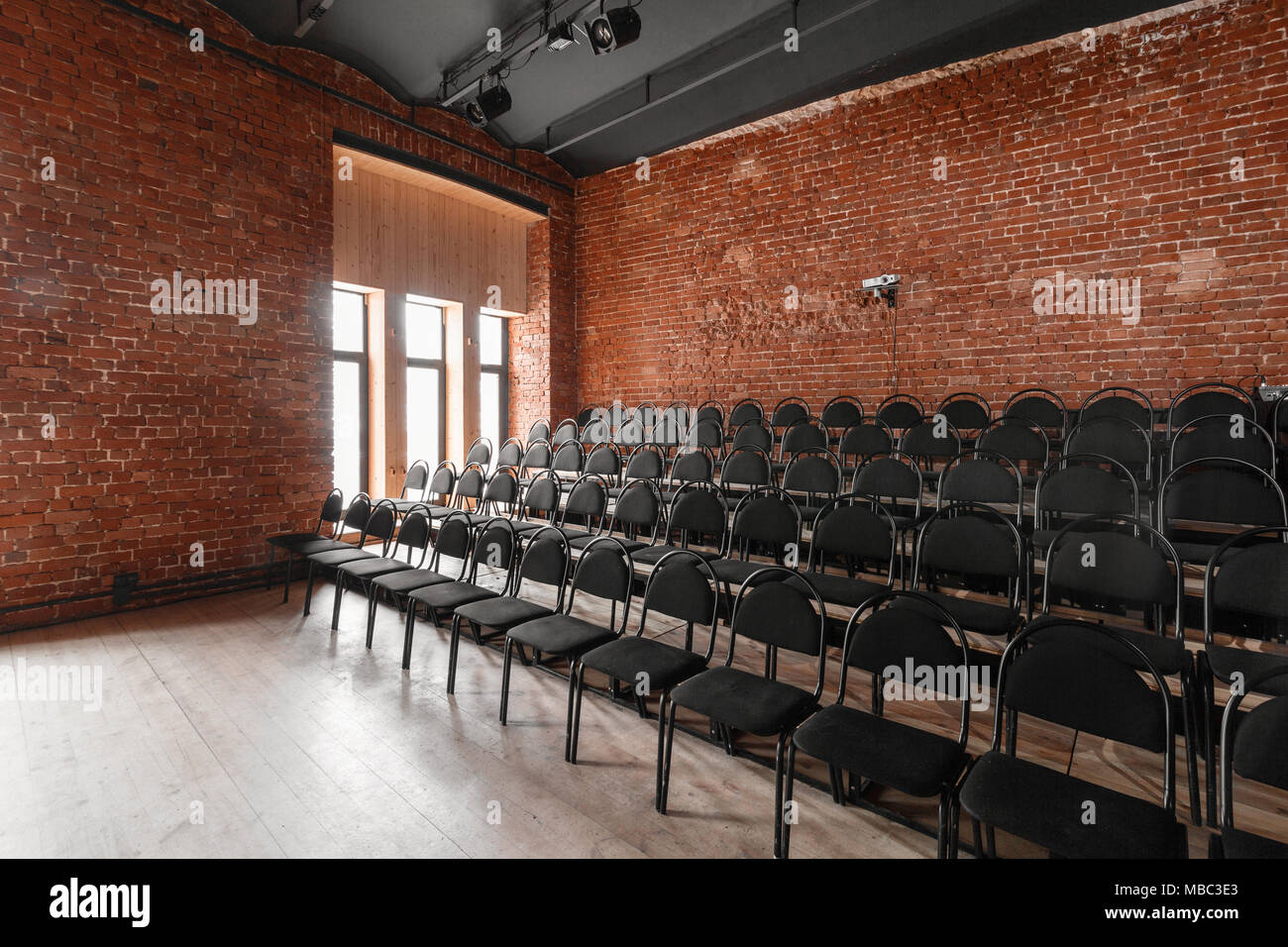 Loft style. Hall with black chairs for webinars and conferences. A huge ...