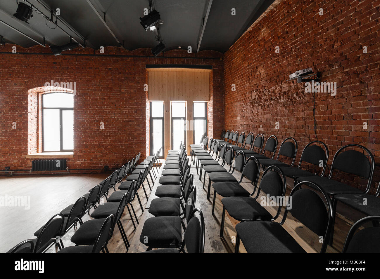 Loft style. Hall with black chairs for webinars and conferences. A huge ...