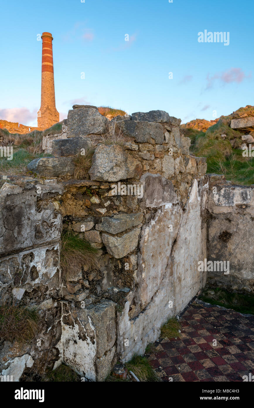 A disused and derelict tine mine with chimneys and engine houses at ...