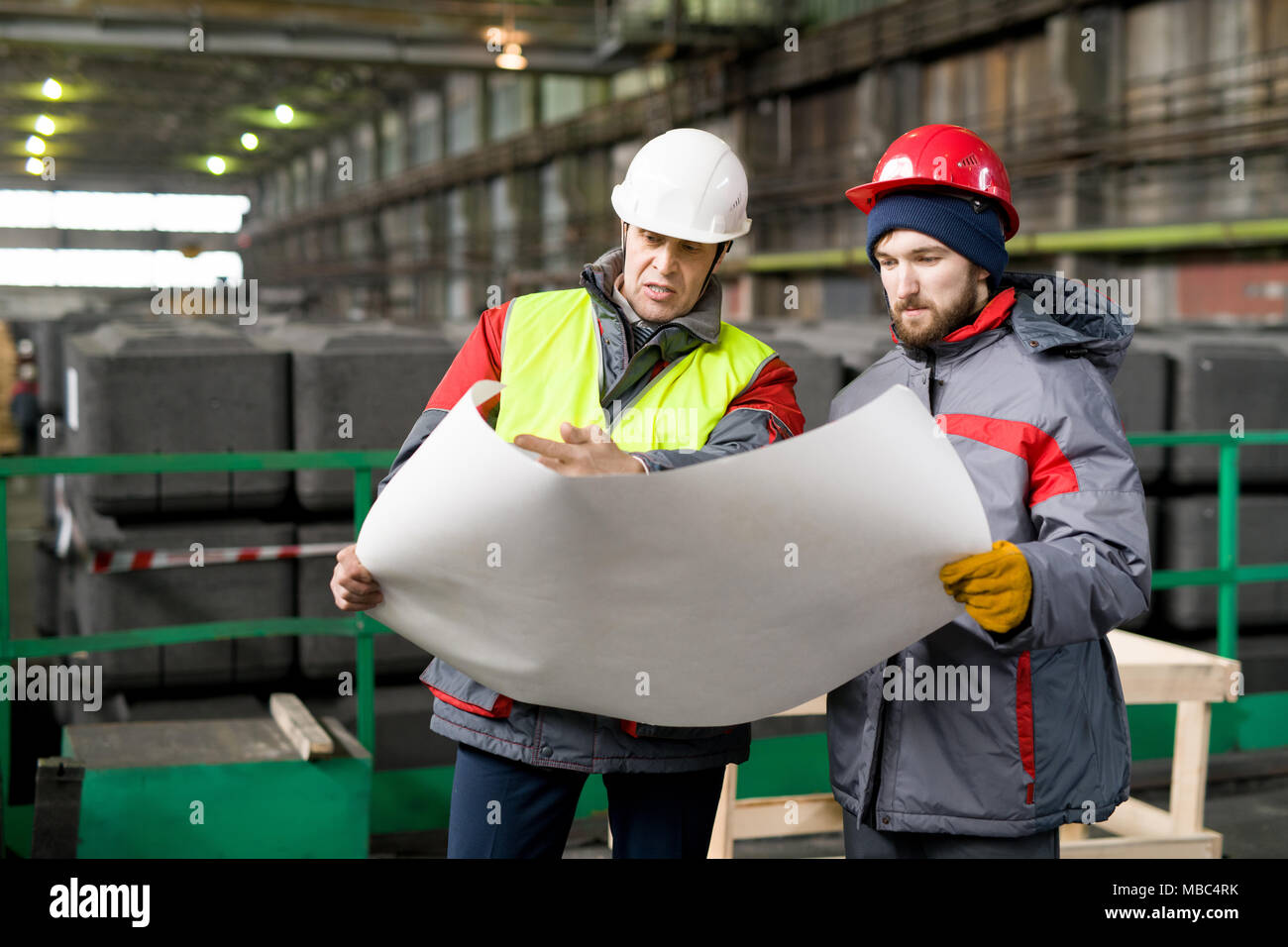 Workers Discussing Schemes at Factory Stock Photo - Alamy