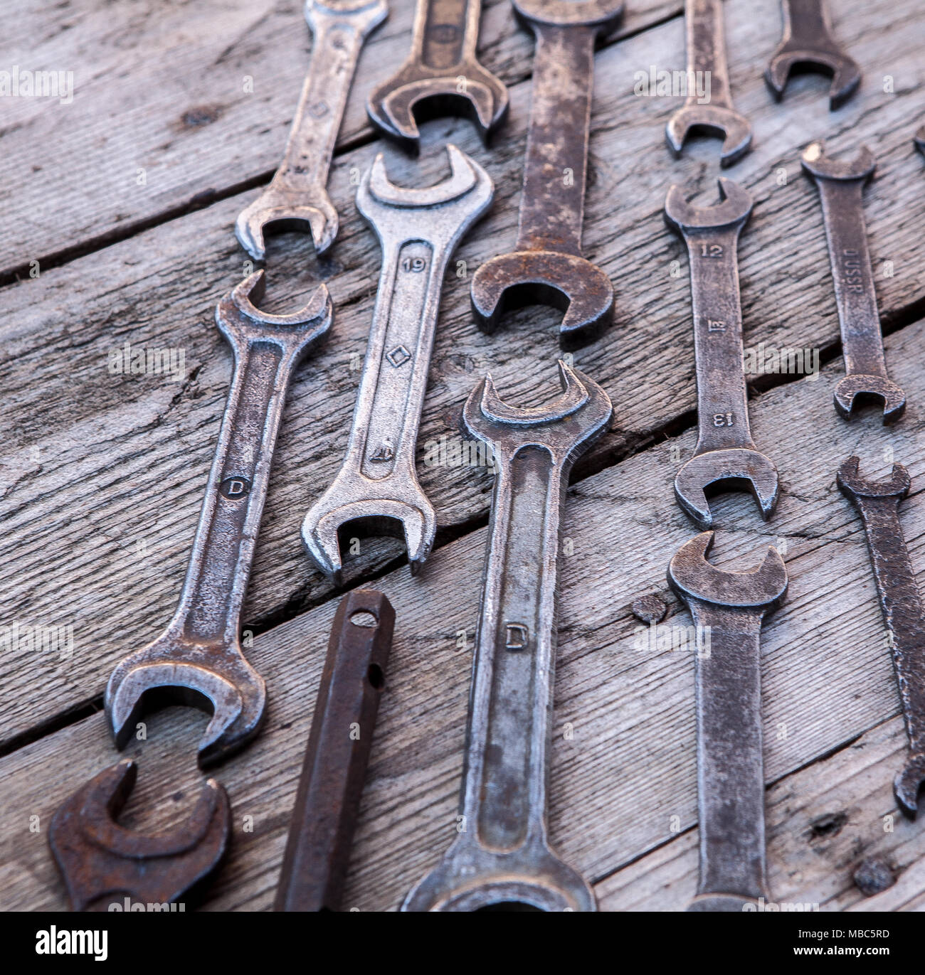 Metal wrench rusty tools lying on a black wooden table. Hammer, chisel ...