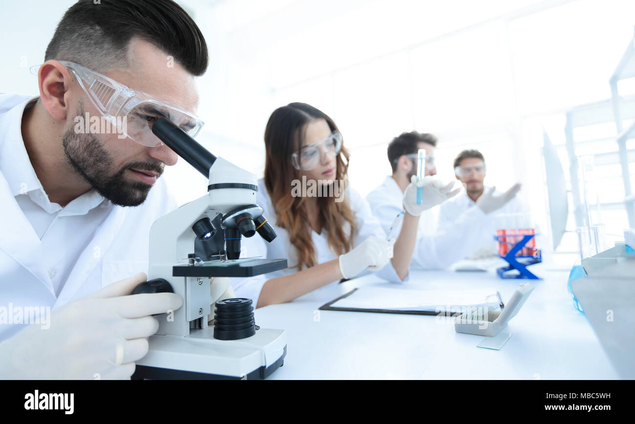 male laboratory technician looking at samples in the microscope Stock ...