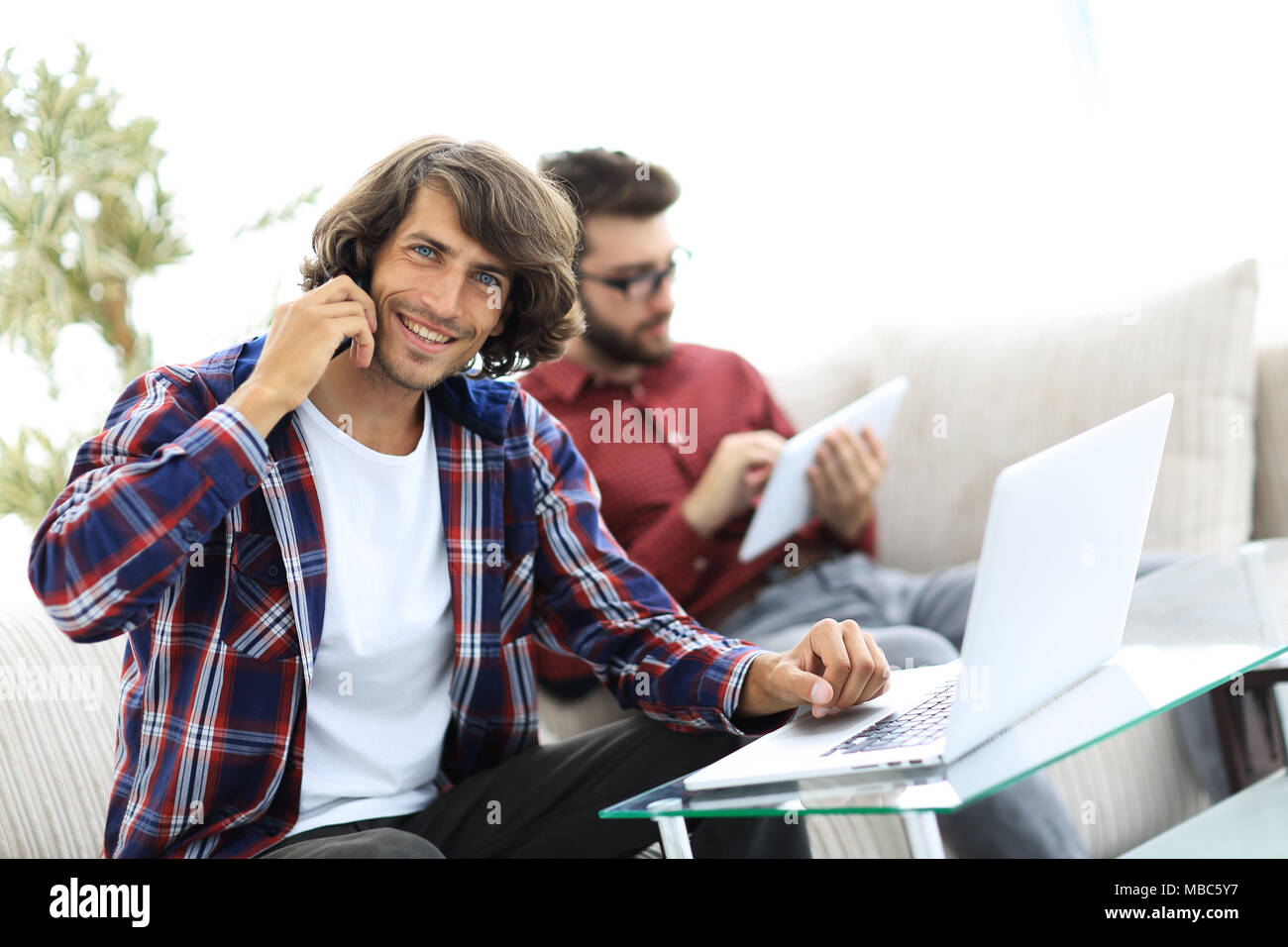 guy with a friend sitting at the desk Stock Photo - Alamy