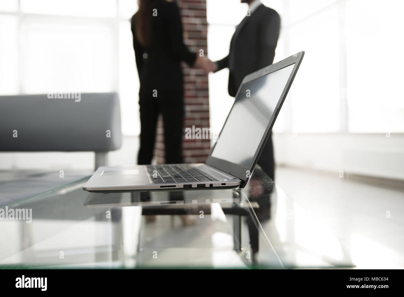 laptop on the desk, background handshake Stock Photo - Alamy