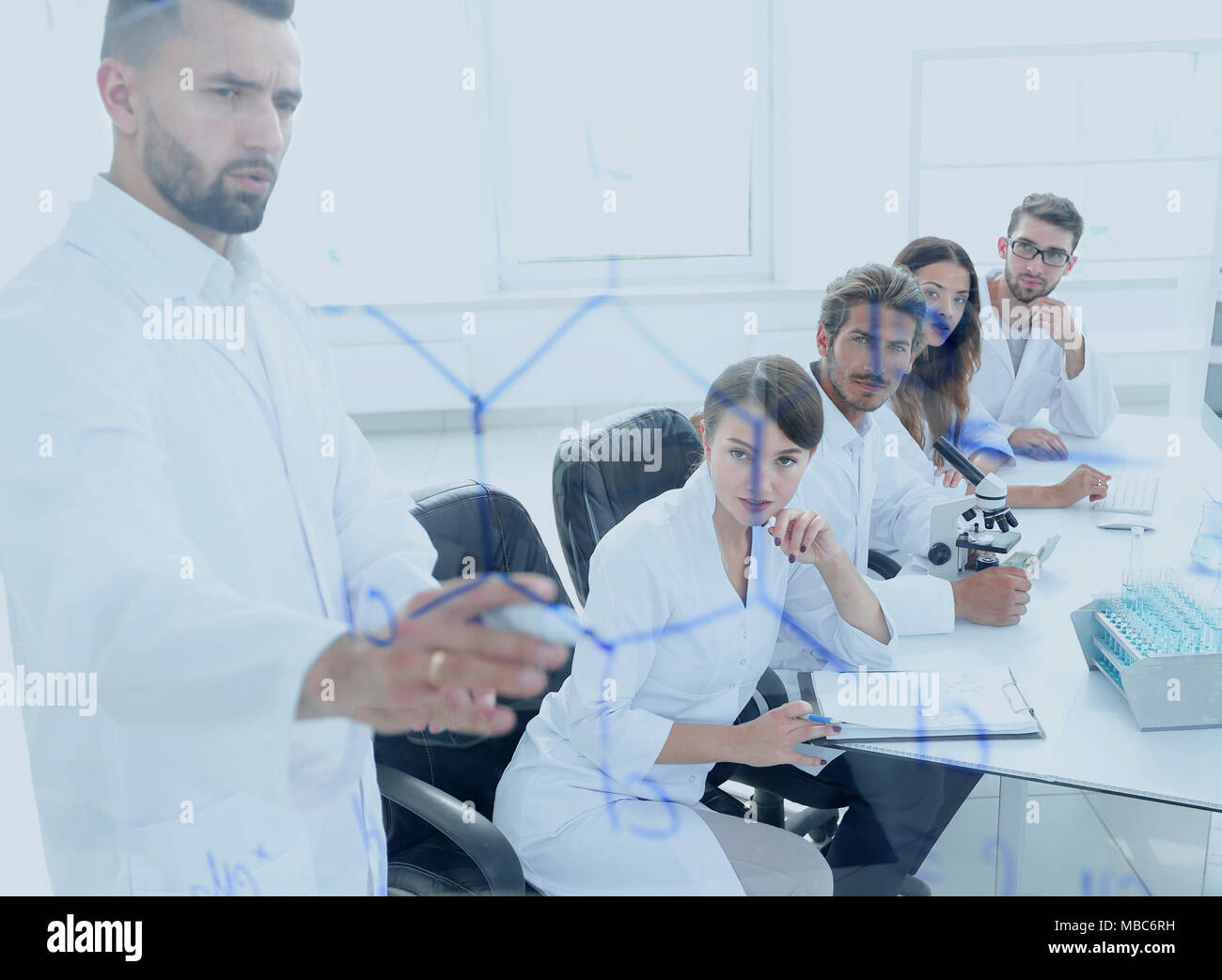 from behind the glass. a scientist standing near the blackboard in the ...