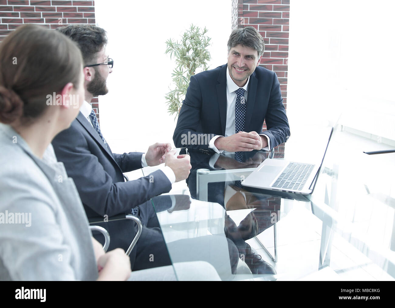 positive manager with his team sitting at the table Stock Photo - Alamy