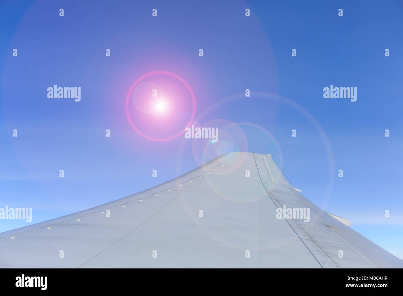 airplane wing with blue sky with lens Flare effect Stock Photo - Alamy