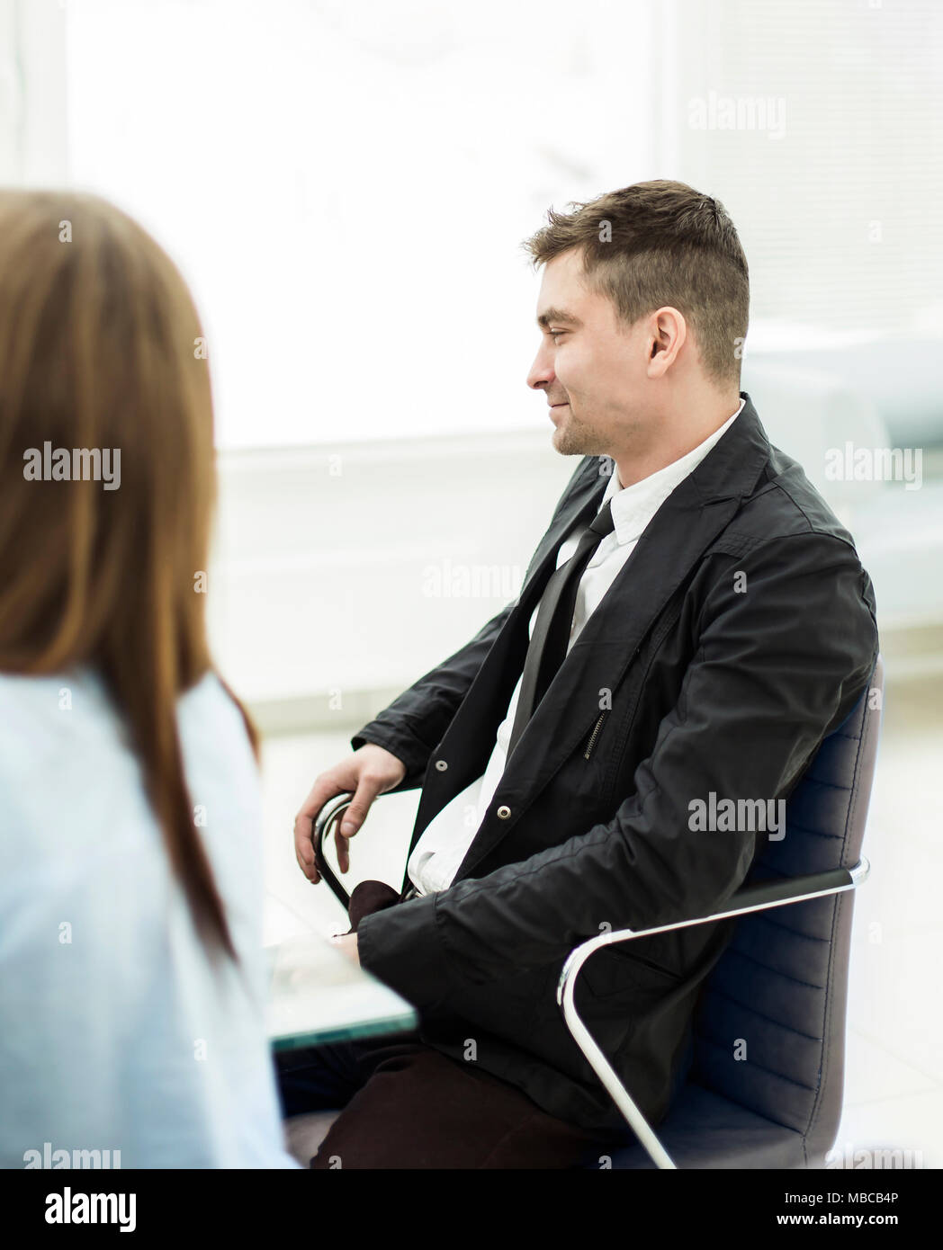 successful employee sitting behind a Desk in the office Stock Photo - Alamy