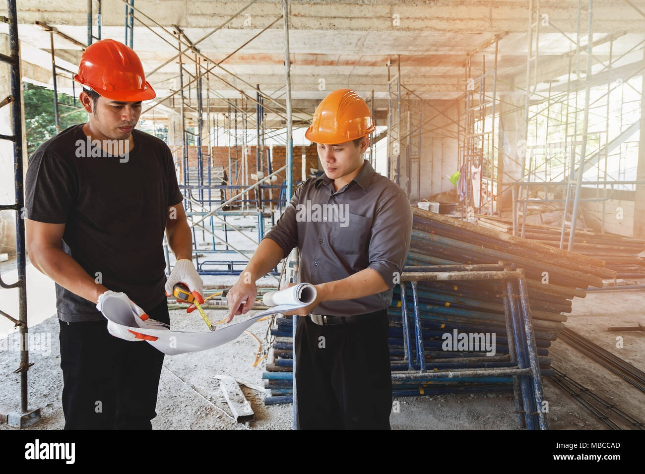 Engineer discussing with foreman about project in building construction ...