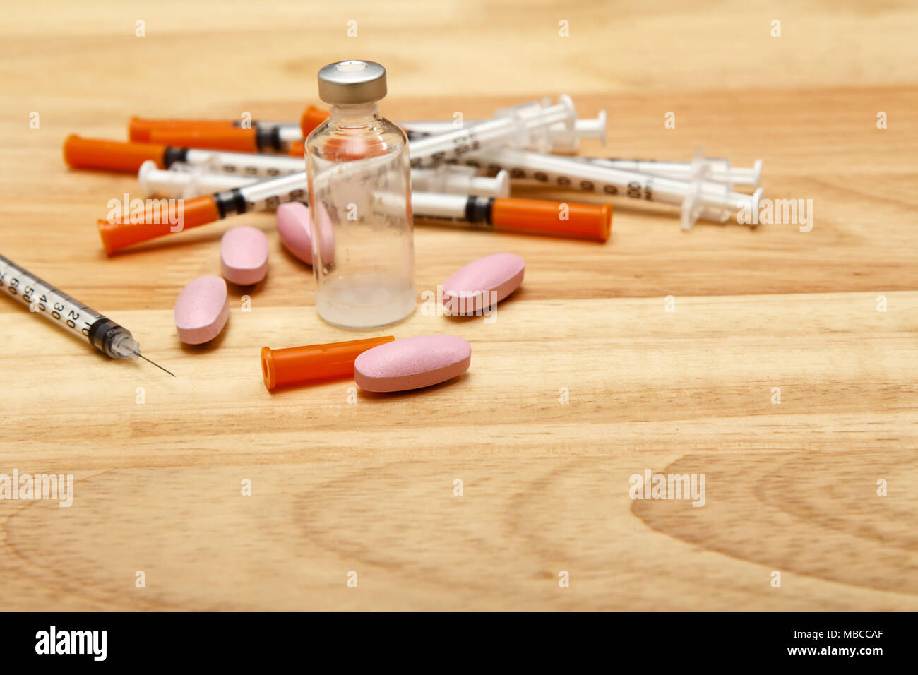 Medical syringe and bottle of potion on wooden desk Stock Photo - Alamy