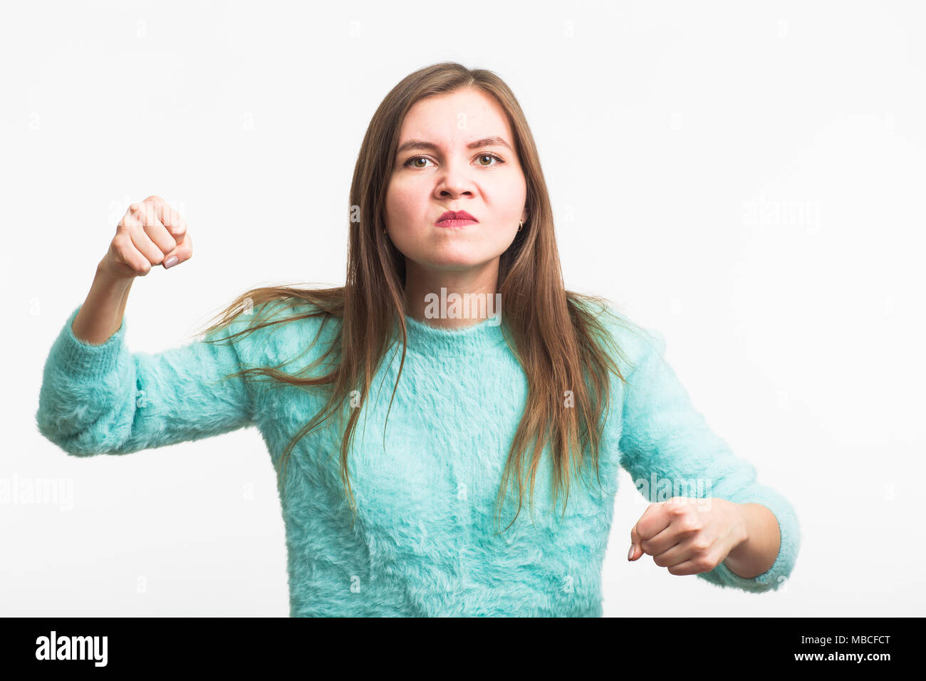 Angry aggressive woman with ferocious expression on white background ...