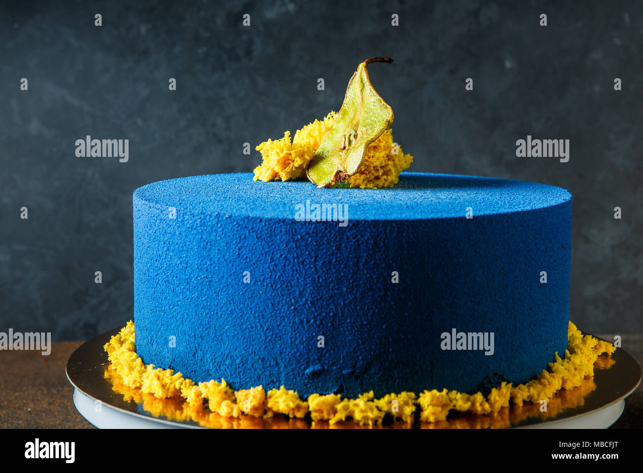 handmade blue round cake decorated with dried pear and pieces of yellow ...