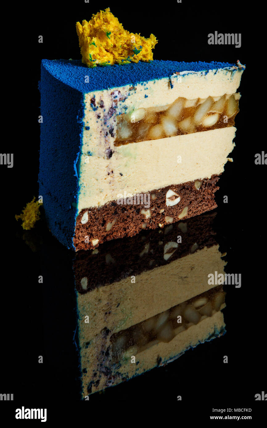 vertical view of piece of delicious blue mousse cake with yellow sponge ...