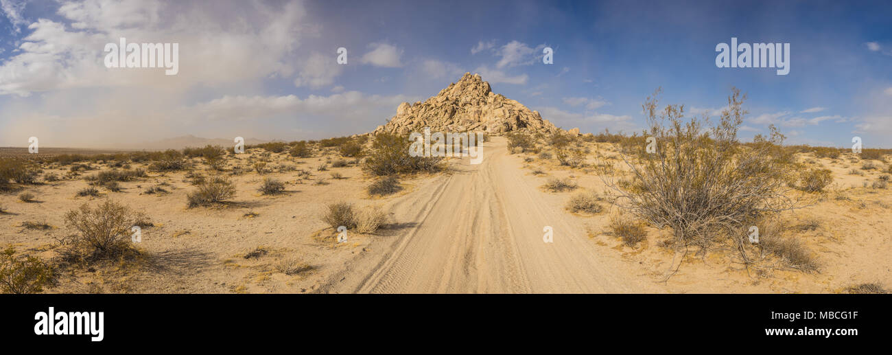 Desert sand road leading through the hot wilderness to a single stone ...