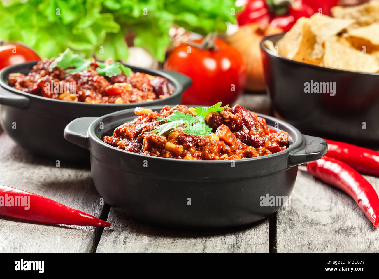 Bowls of hot chili con carne with ground beef, beans, tomatoes and corn ...