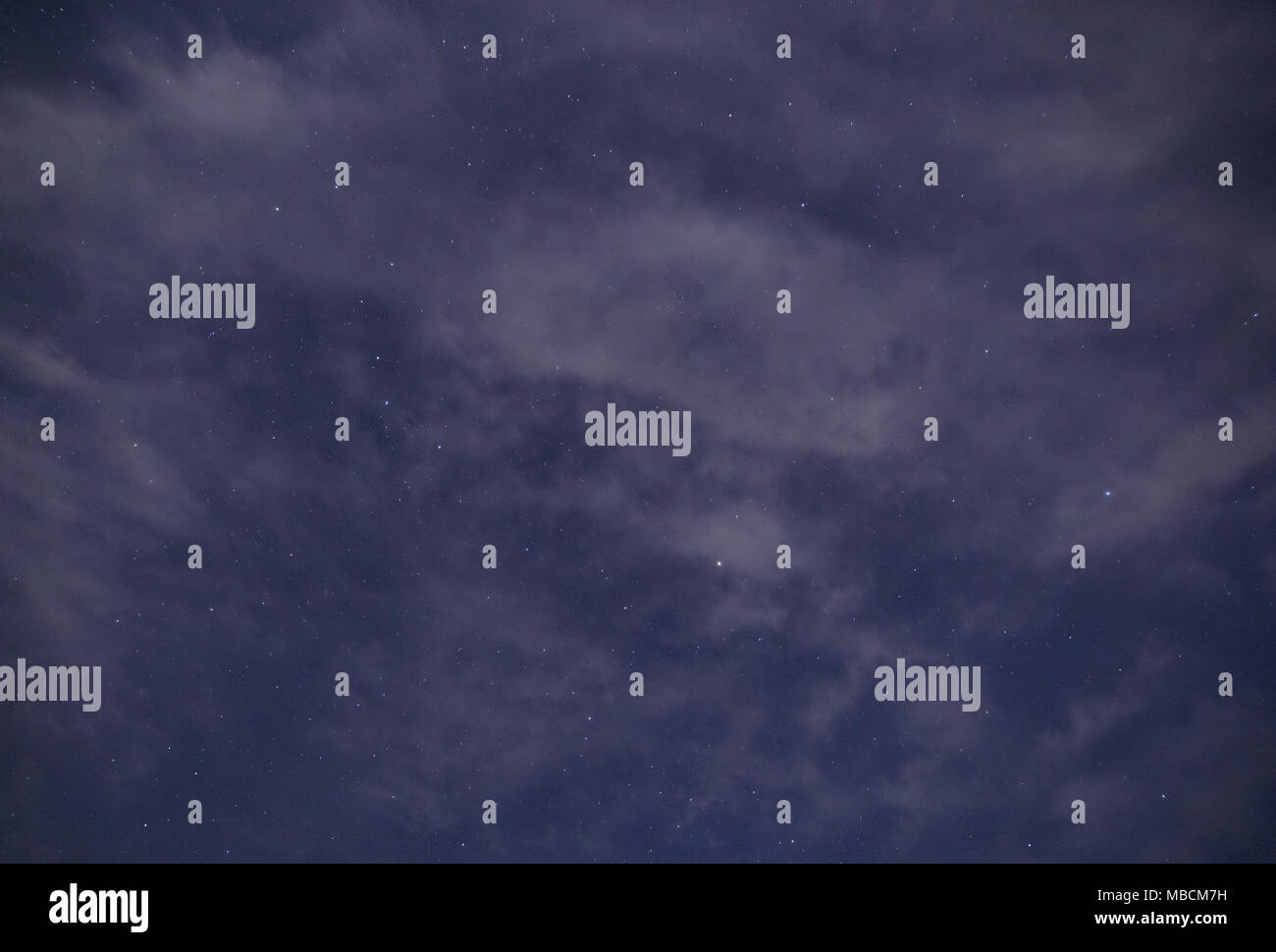 view on cloudy sky with stars at night Stock Photo - Alamy