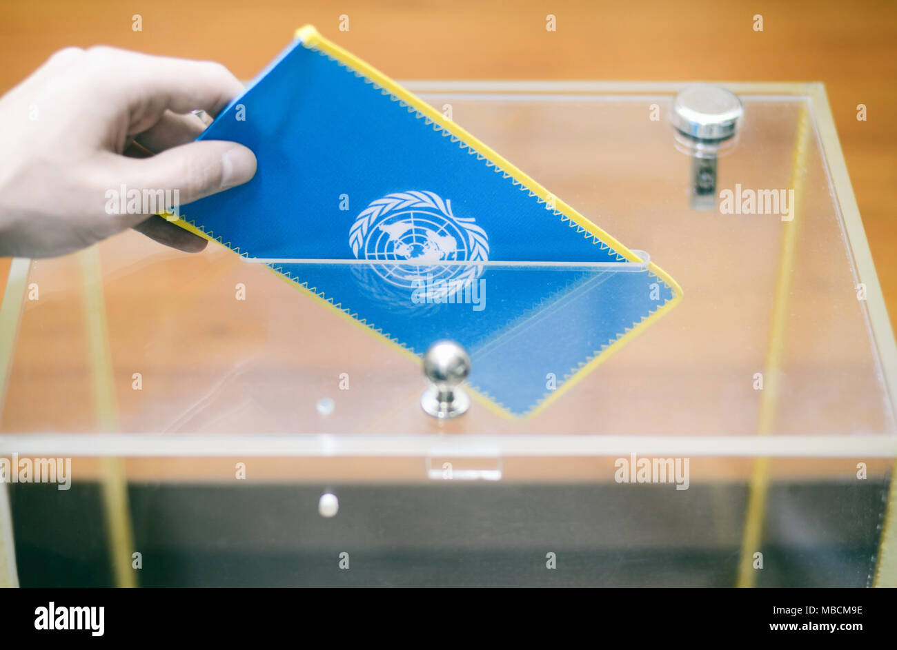 Man inserting Flag of United Nations into ballot box, voting and ...