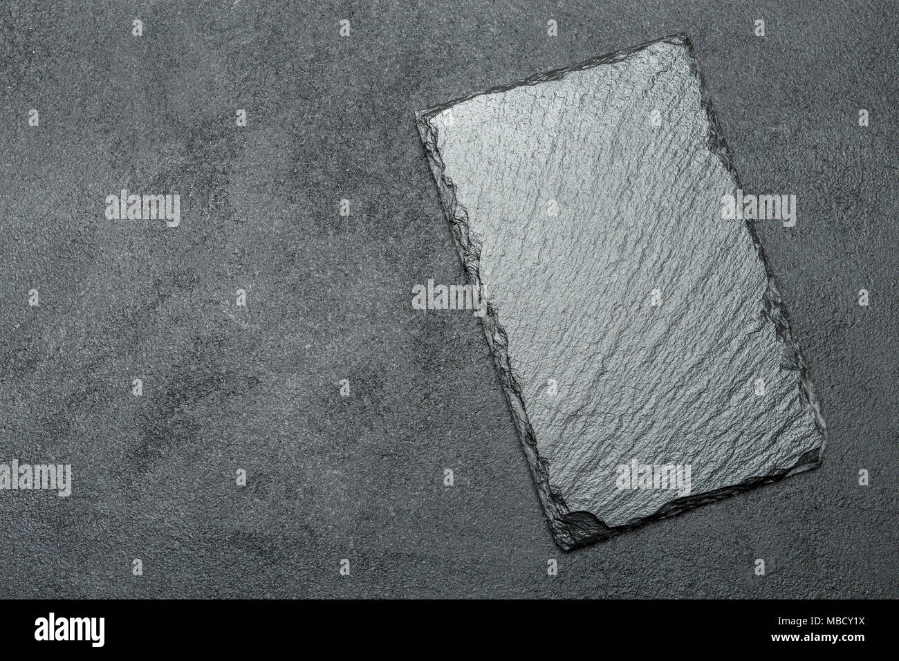decorative stone serving board on concrete background Stock Photo - Alamy