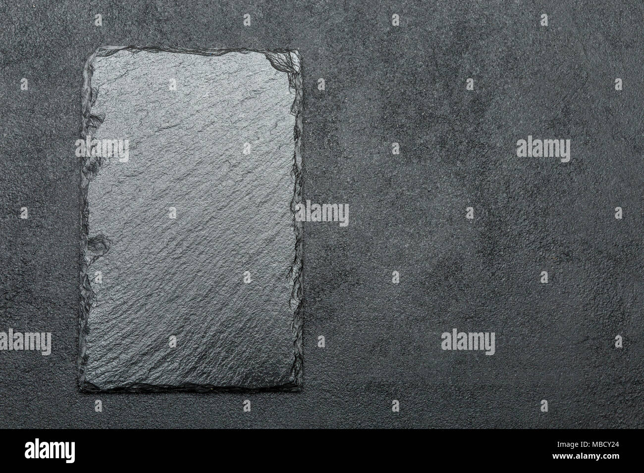 decorative stone serving board on concrete background Stock Photo - Alamy