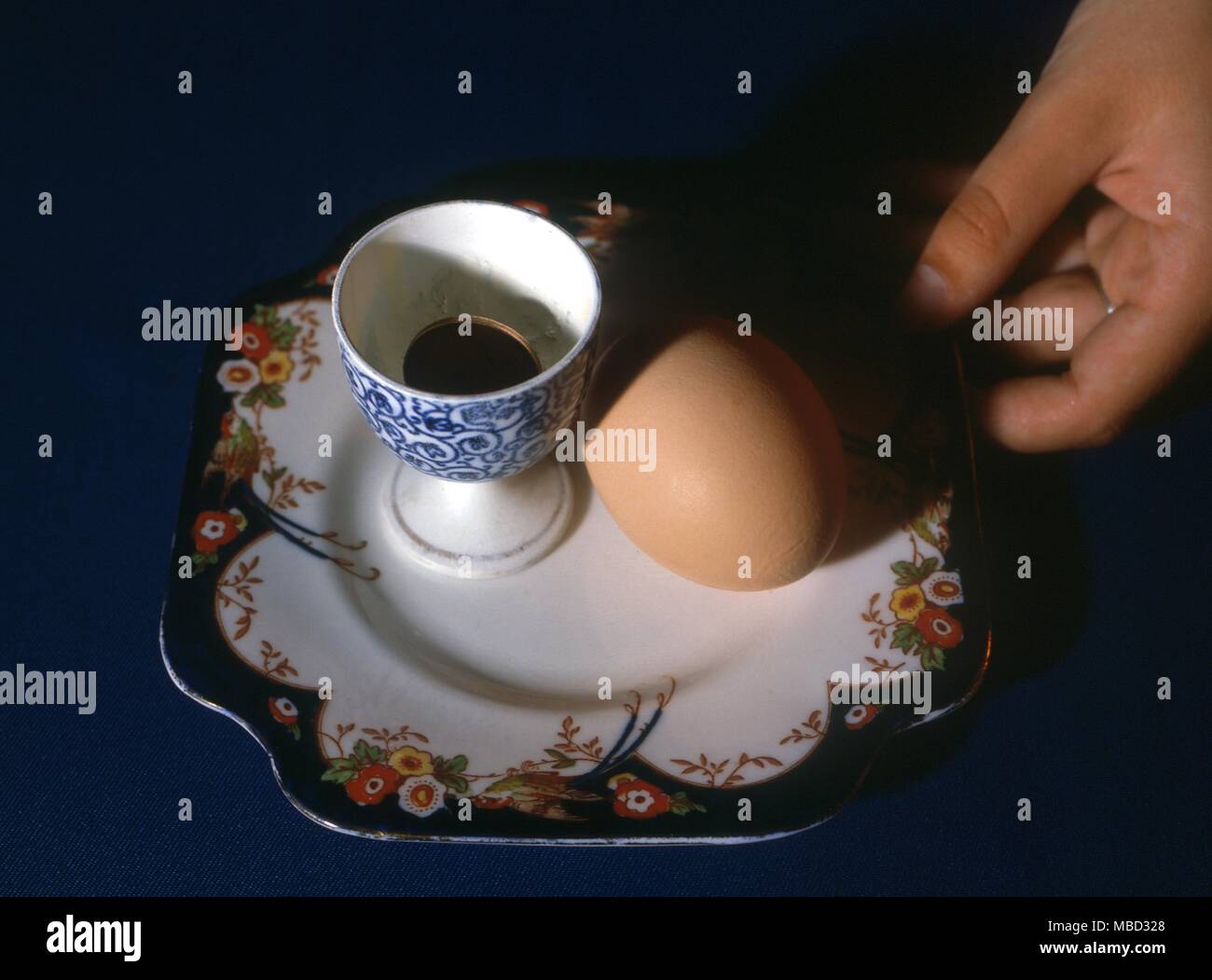 Stage Magic - Coin in Egg. The magician puts an egg into an eggcup ...