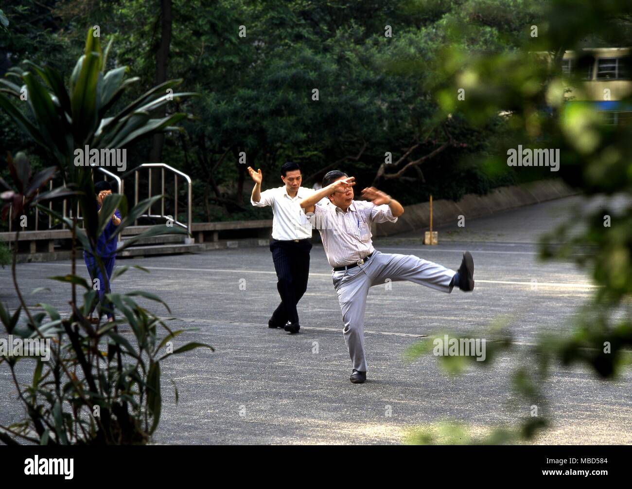 Chinese master of Tai Chi with his students in a park in Hong Kong ...