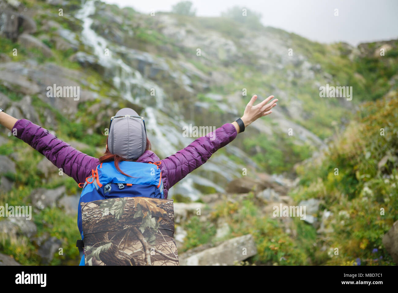 Picture from back of woman with backpack with hands up Stock Photo - Alamy