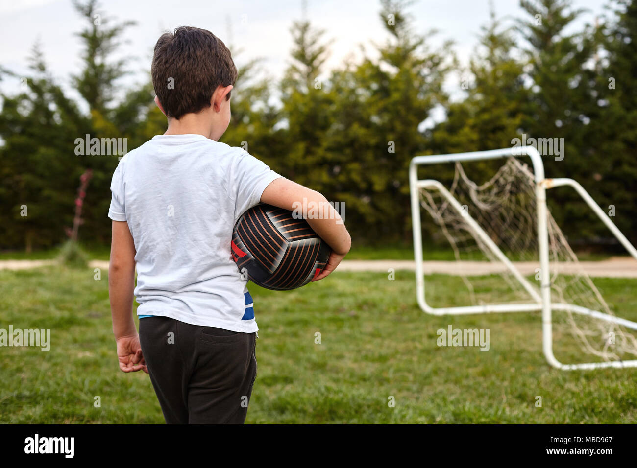 Kid holding ball hi-res stock photography and images - Alamy