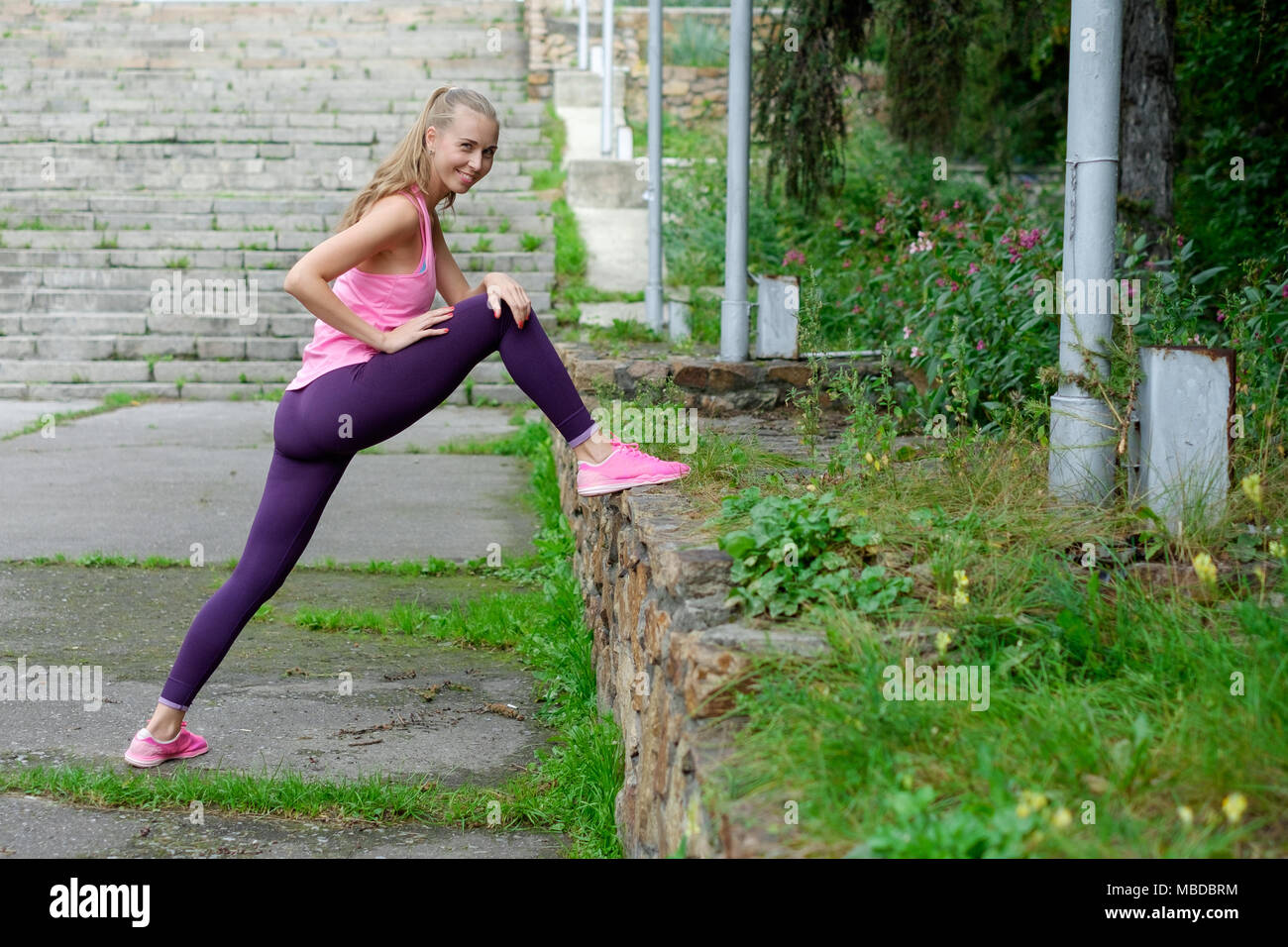 Female runner with beautiful figure doing stretching exercise Stock ...