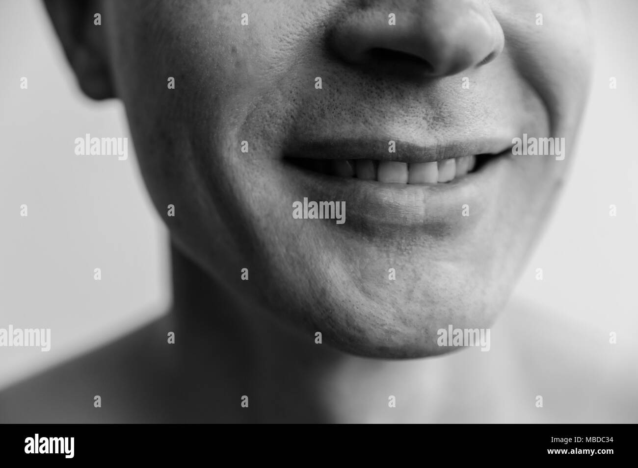 Easy smile closeup. The lower part of the face of a man. Black and ...