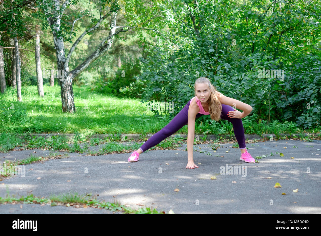 Female runner with beautiful figure doing stretching exercise Stock ...