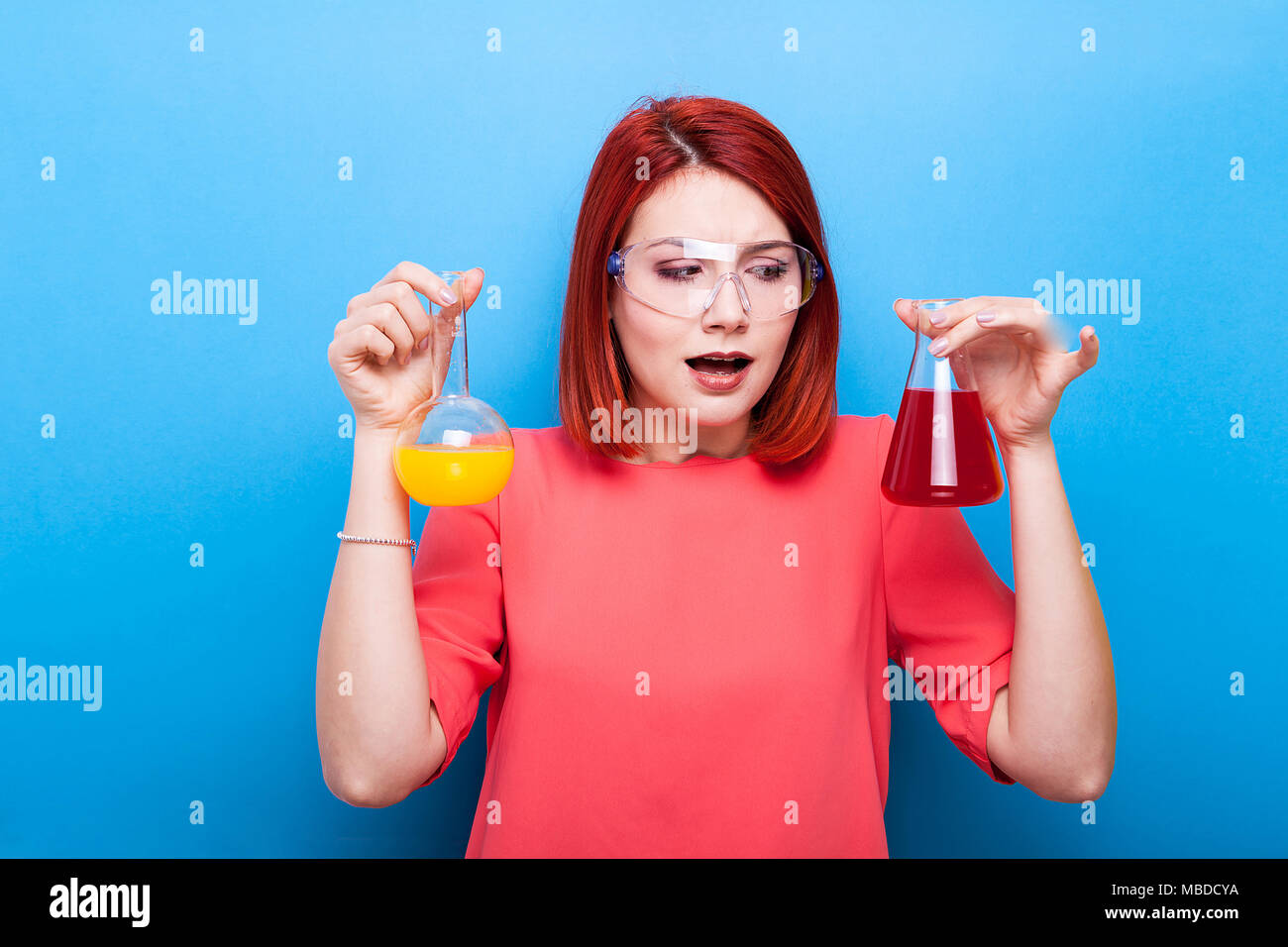 Confused chemist woman with two tubes with yellow and red liquid Stock ...