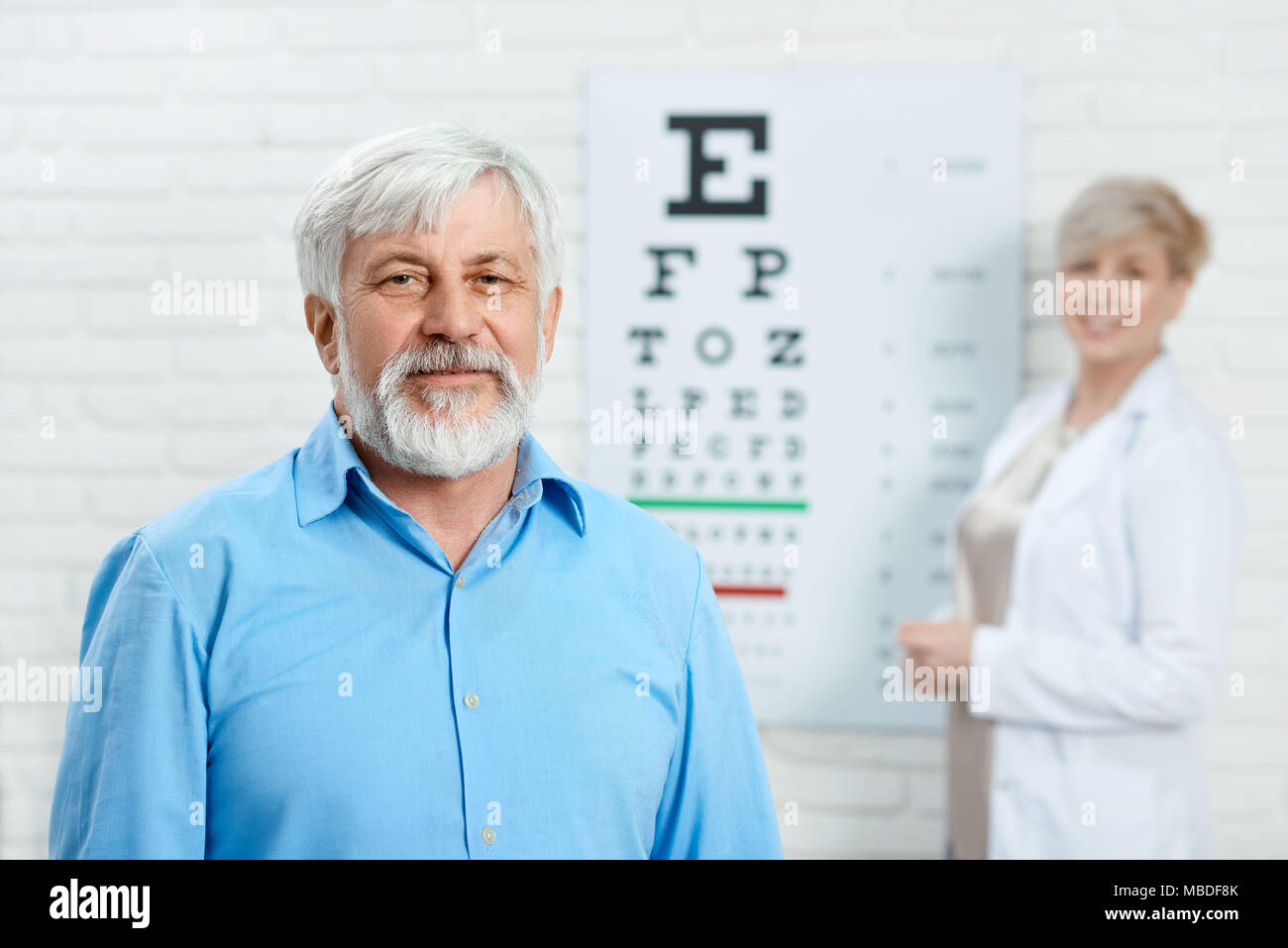 Old patient staying in front of ophthalmologist. Looks satisfied ...