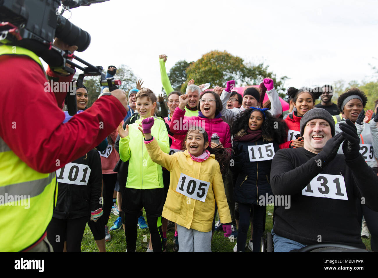 Cameraman filming cheering crowd of runners at charity race Stock Photo ...