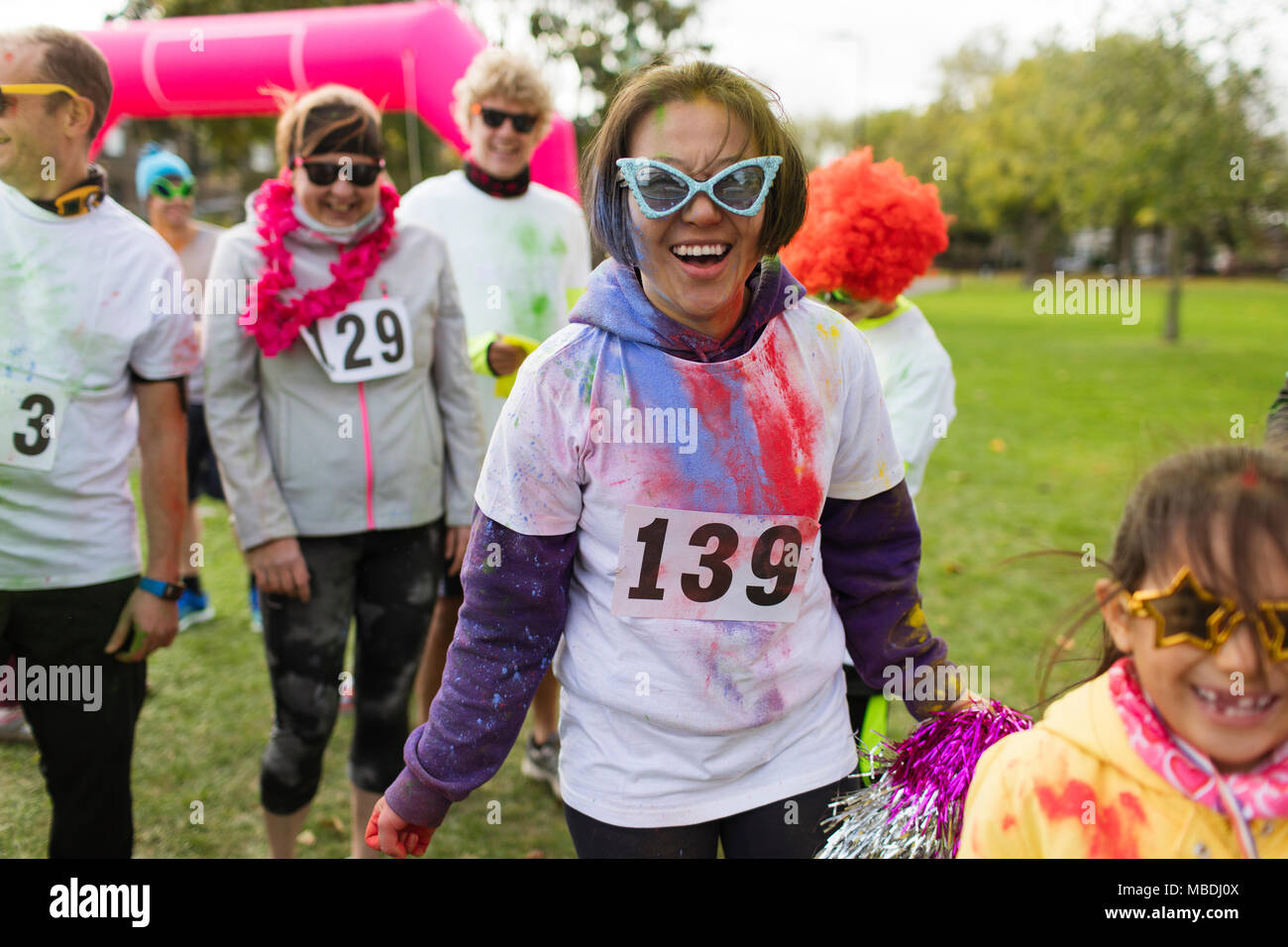 Portrait smiling, playful female runner in silly sunglasses at charity ...