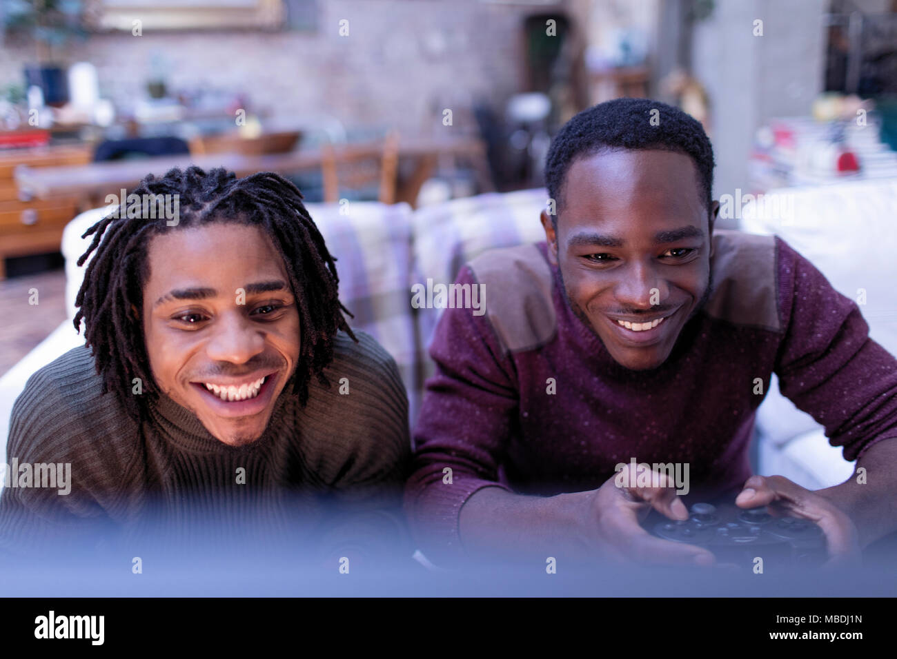 Smiling brothers playing video game Stock Photo - Alamy