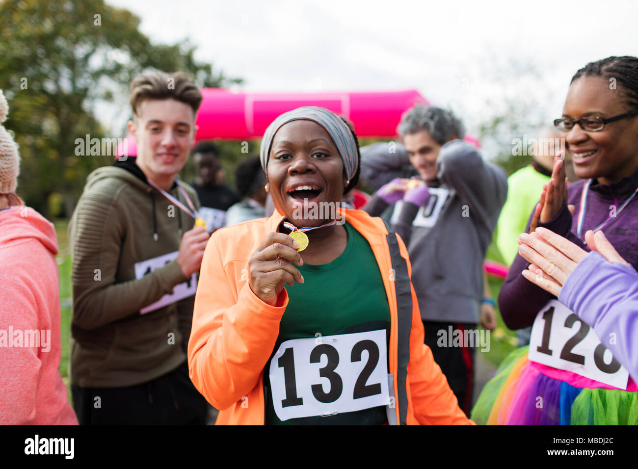Portrait enthusiastic female runner showing medal at charity run Stock ...