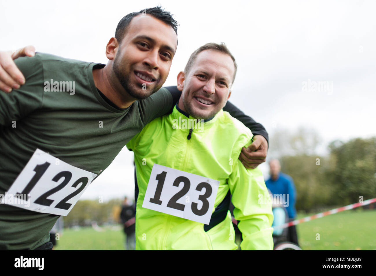 Portrait smiling male marathon runners hugging Stock Photo - Alamy